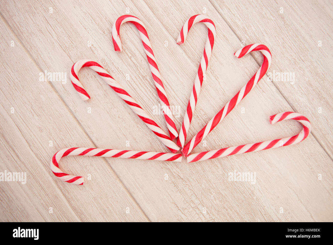 Red and white candy canes on a gray wooden background Stock Photo - Alamy