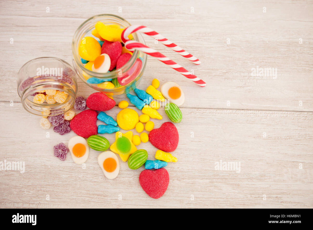 Candies with different shapes and colors on a gray wooden background ...