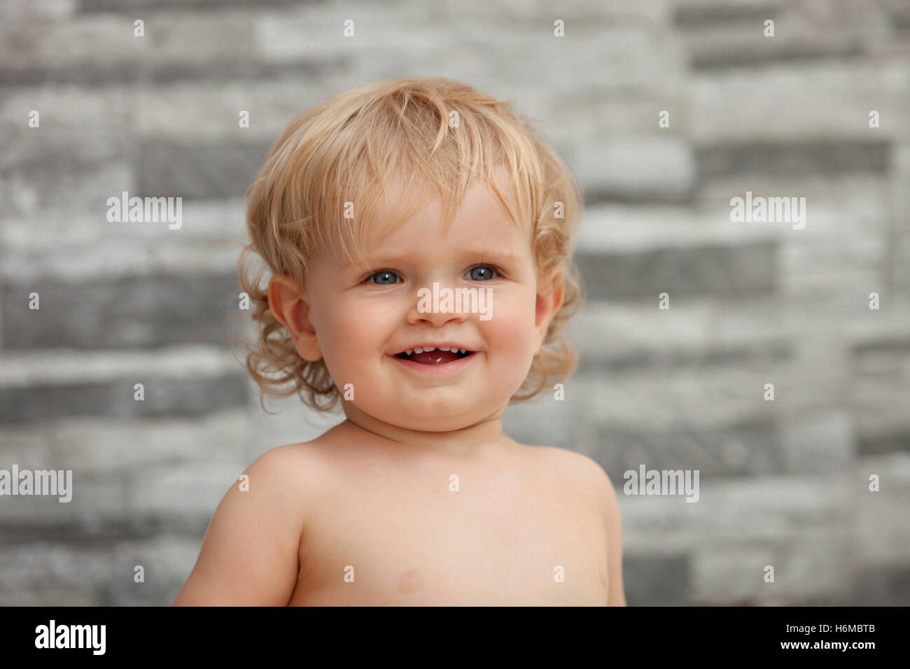 Happy baby one years old with blond and curly hair at outside Stock ...