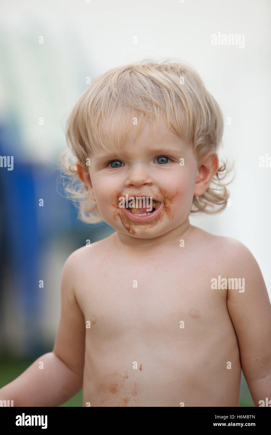 Happy baby with a dirty face after eat chocolate ice Stock Photo - Alamy