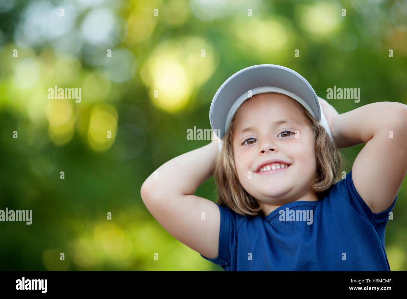 Little cute girl with a cap in the park happy Stock Photo - Alamy