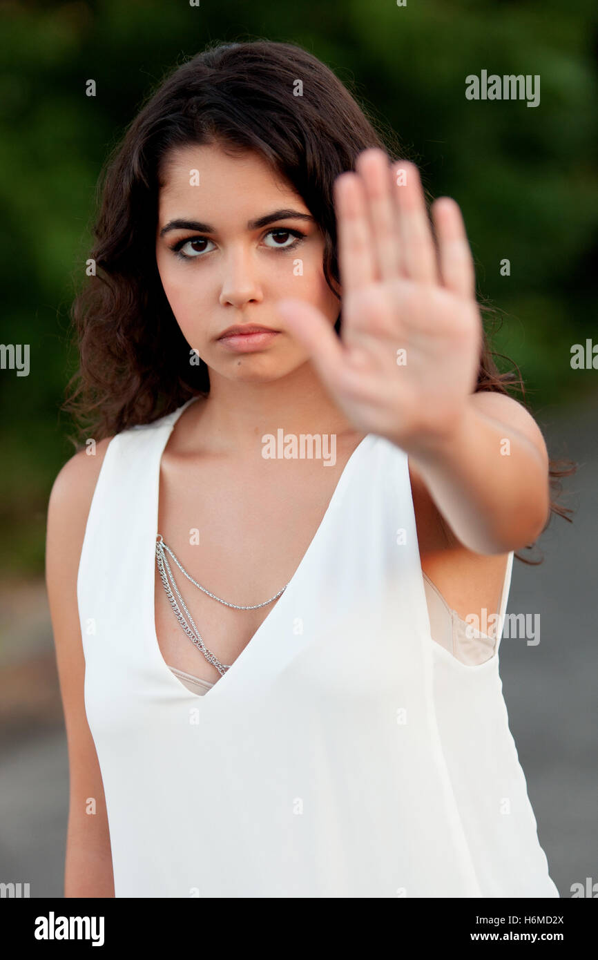 Serious brunette girl making stop sign in the park Stock Photo - Alamy