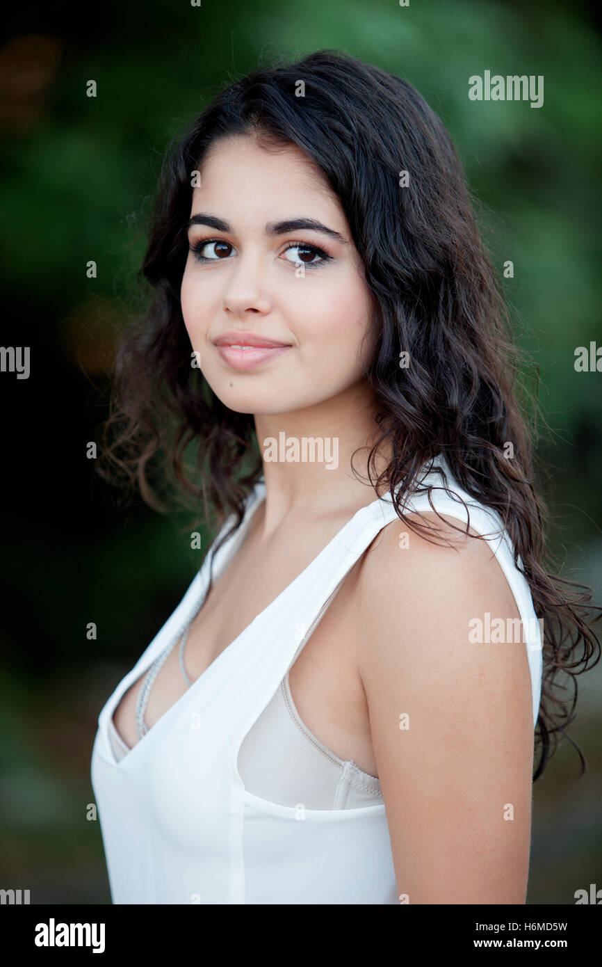 Beautiful brunette girl relaxing in the park wiht many plants of ...