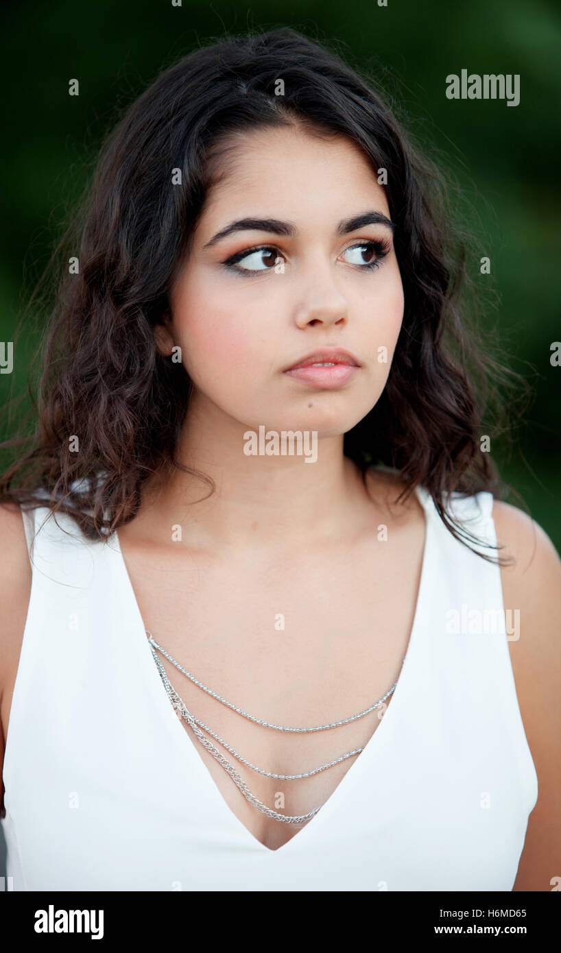 Beautiful Brunette Girl Relaxing In The Park Wiht Many Plants Of