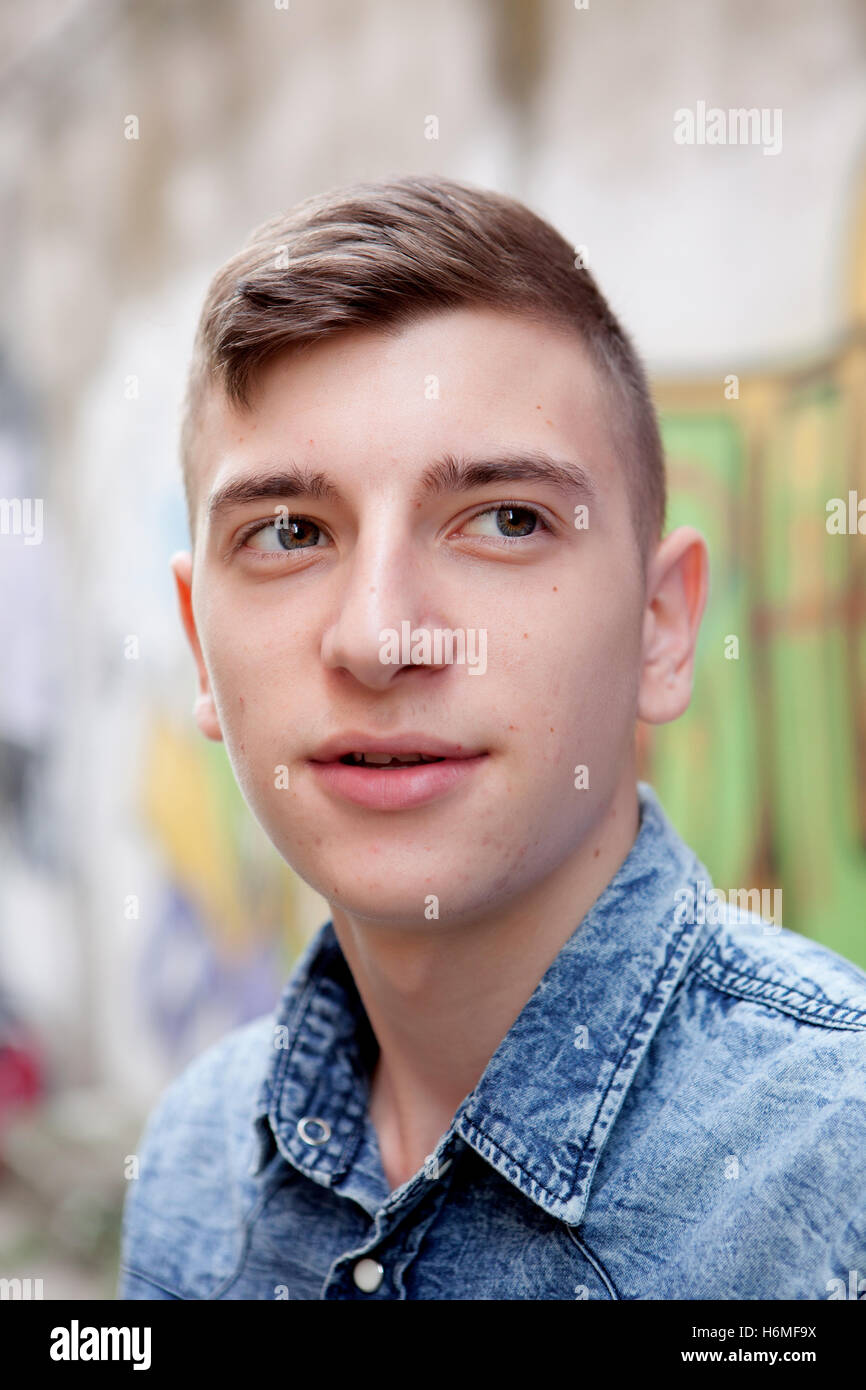 Portrait of a teenager rebellious man on a wall with graffiti ...