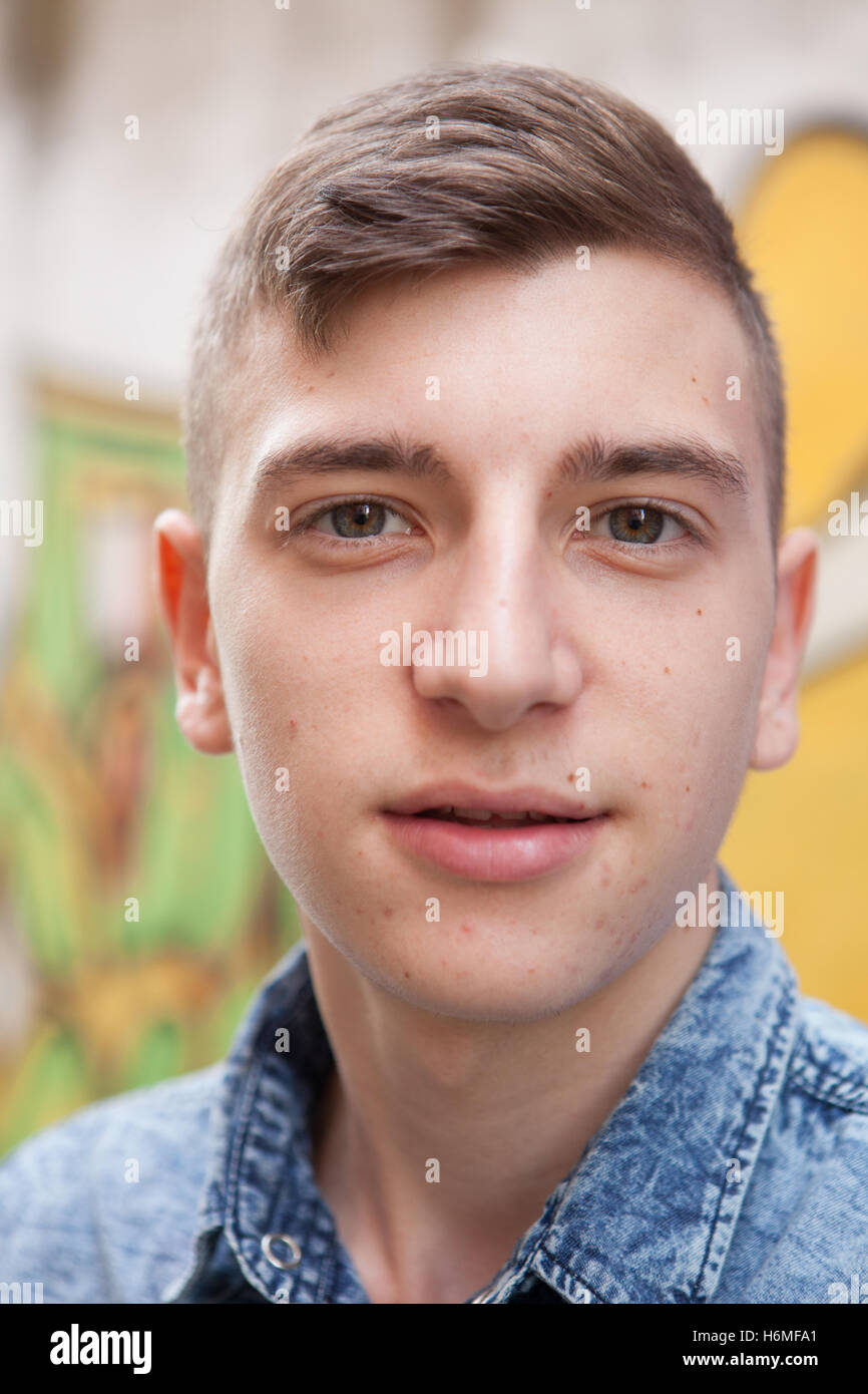 Portrait of a teenager rebellious man on a wall with graffiti ...