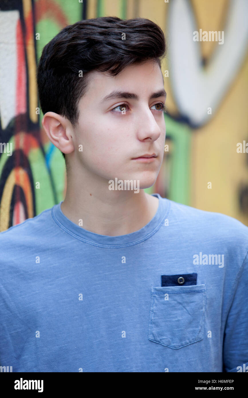 Portrait of a teenager rebellious man on a wall with graffiti ...