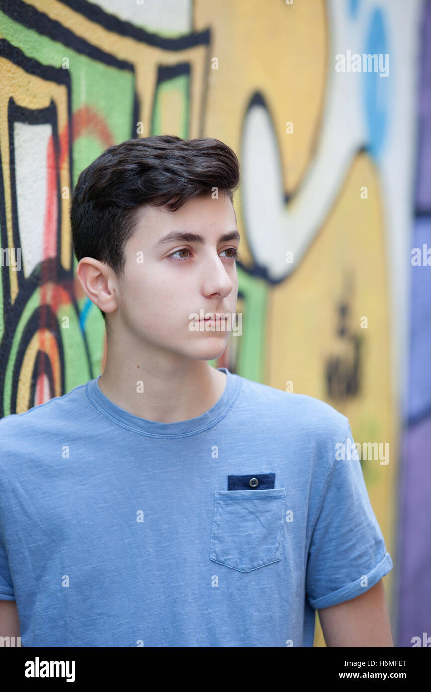 Portrait of a teenager rebellious man on a wall with graffiti ...