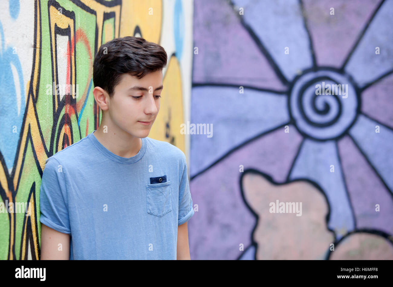 Portrait of a teenager rebellious man on a wall with graffiti ...