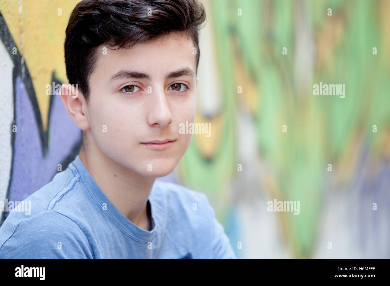 Portrait of a teenager rebellious man on a wall with graffiti ...