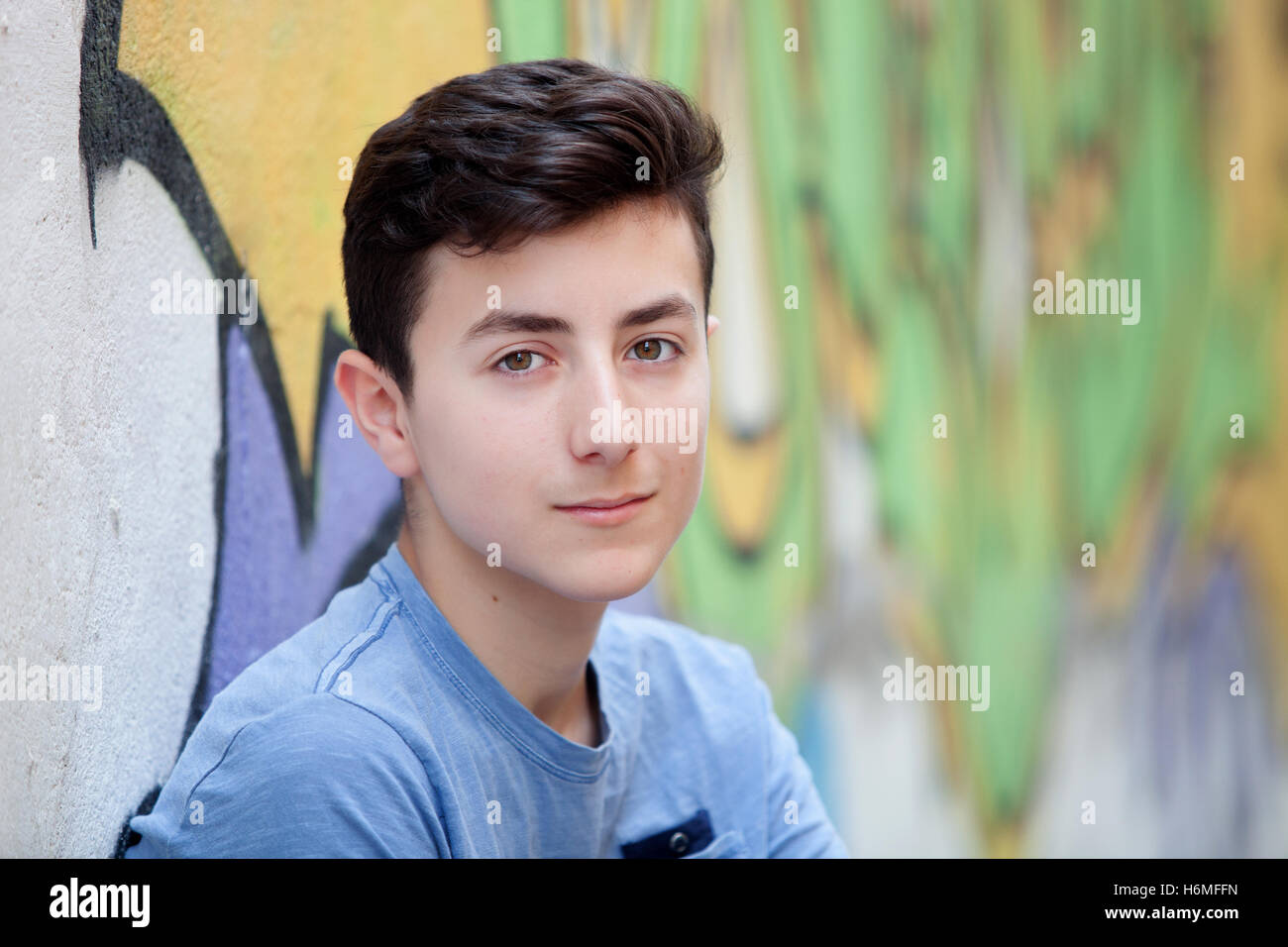 Portrait of a teenager rebellious man on a wall with graffiti ...