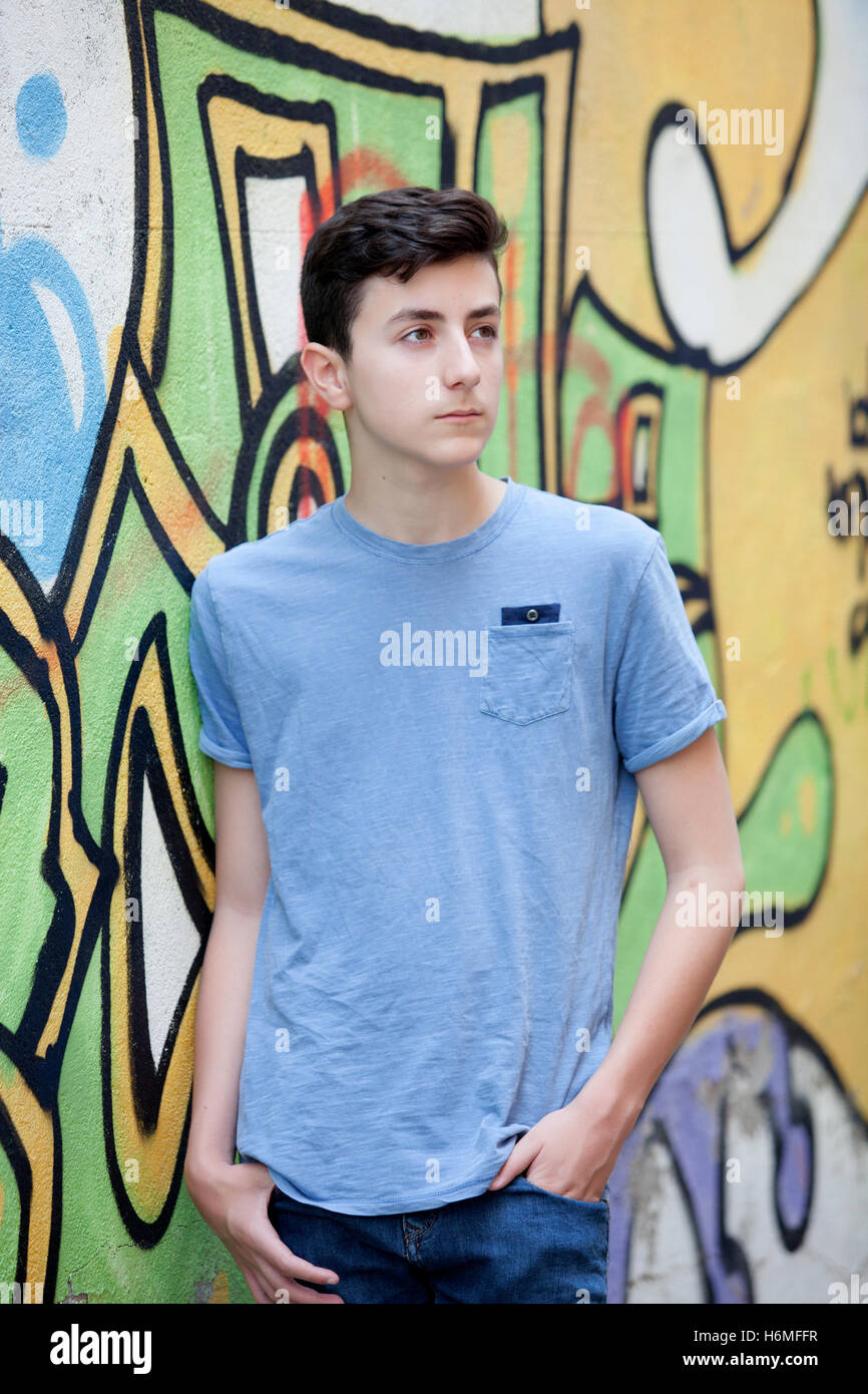 Portrait of a teenager rebellious man on a wall with graffiti ...