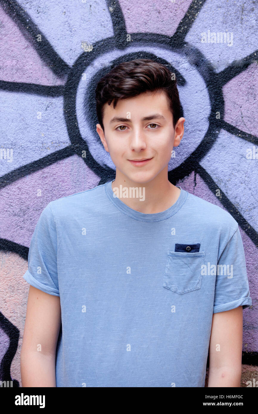 Portrait of a teenager rebellious man on a wall with graffiti ...