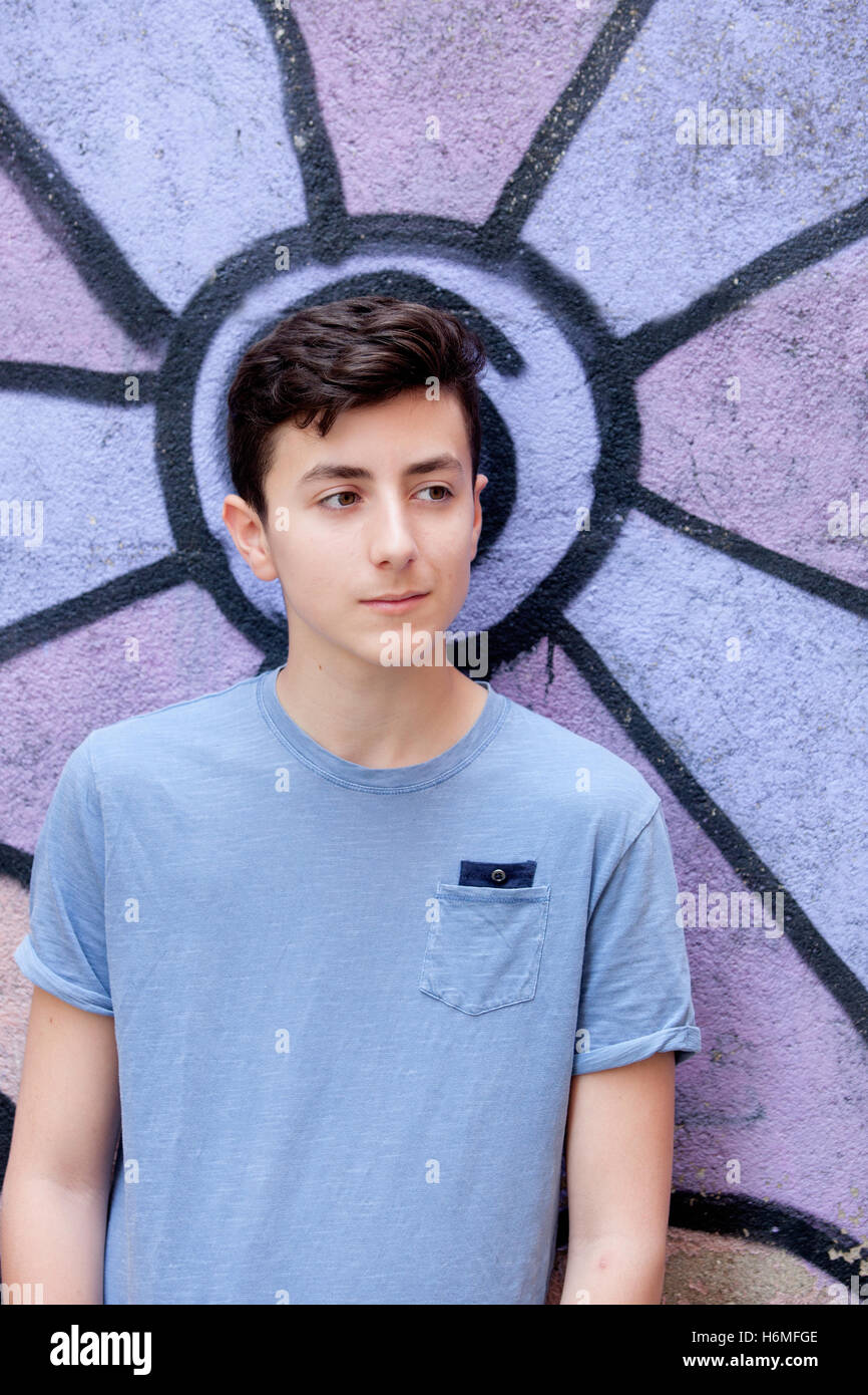 Portrait of a teenager rebellious man on a wall with graffiti ...