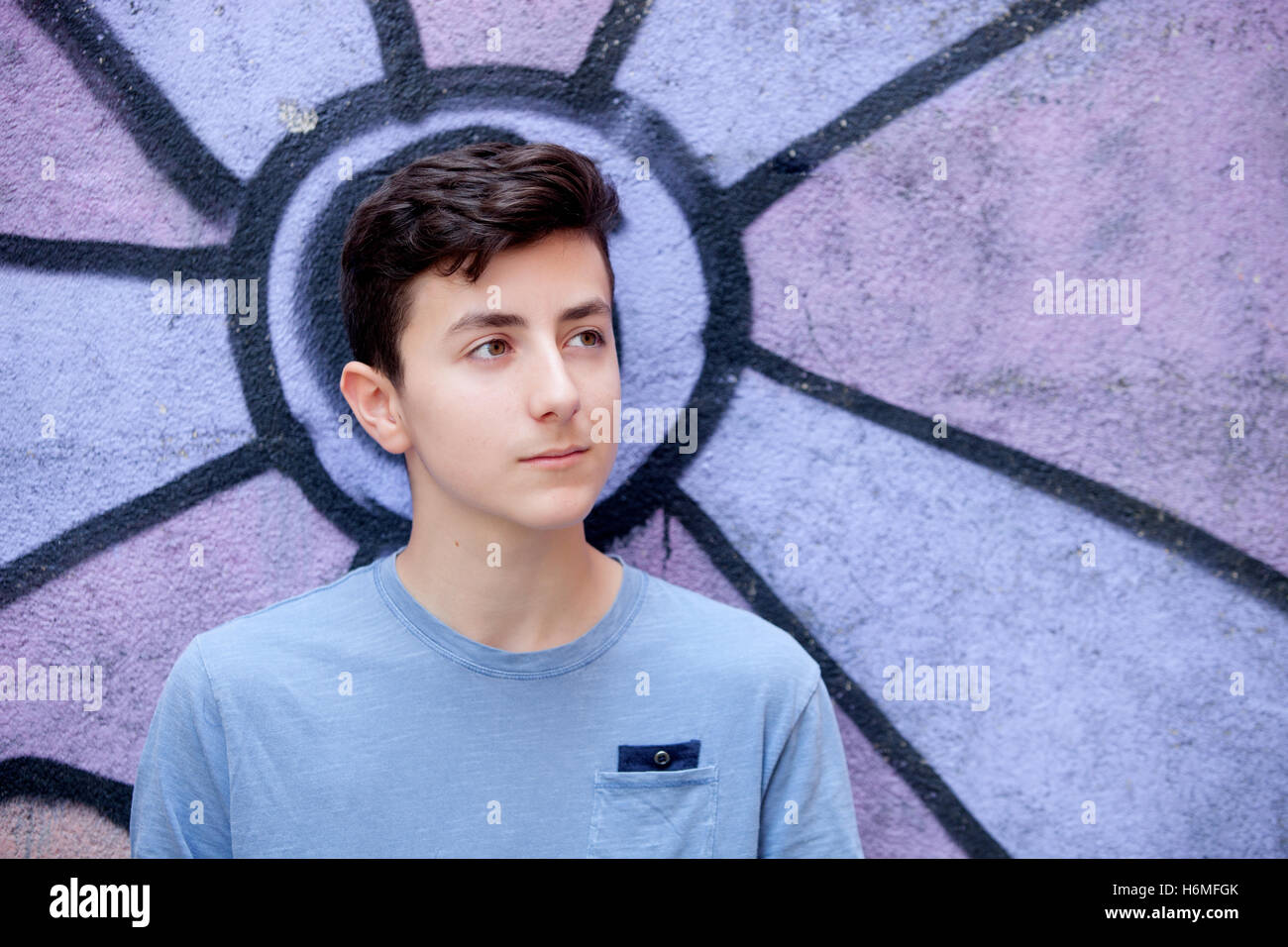Portrait of a teenager rebellious man on a wall with graffiti ...