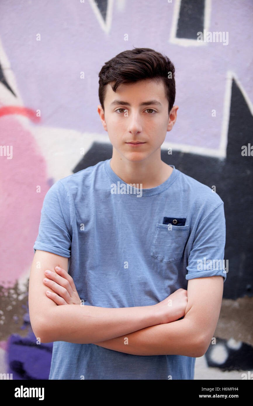 Portrait of a teenager rebellious man on a wall with graffiti ...