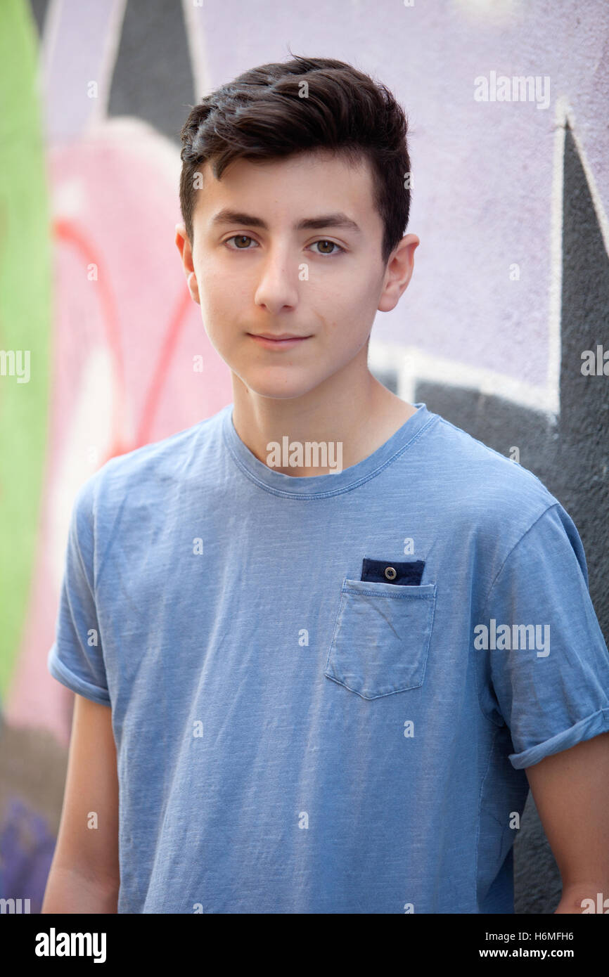Portrait of a teenager rebellious man on a wall with graffiti ...