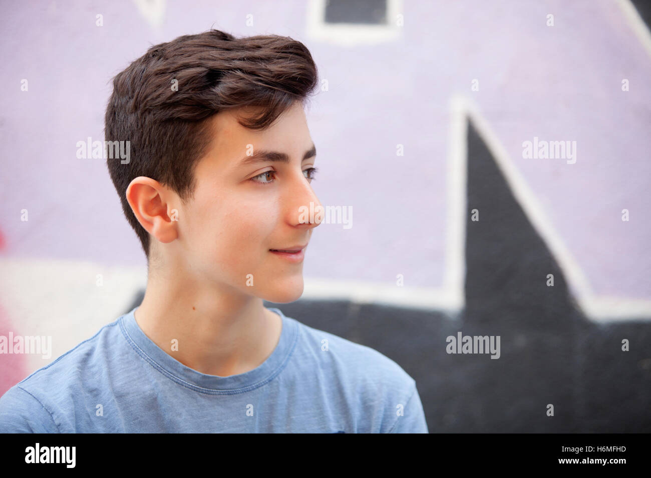 Portrait of a teenager rebellious man on a wall with graffiti ...