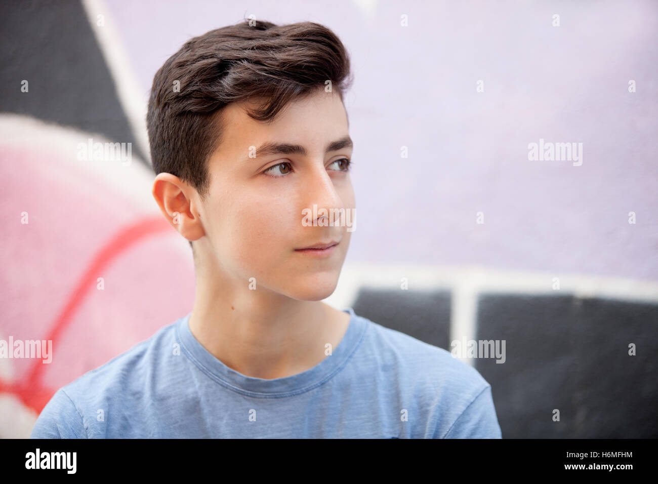 Portrait of a teenager rebellious man on a wall with graffiti ...