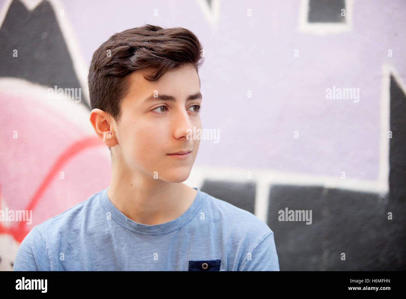 Portrait of a teenager rebellious man on a wall with graffiti ...