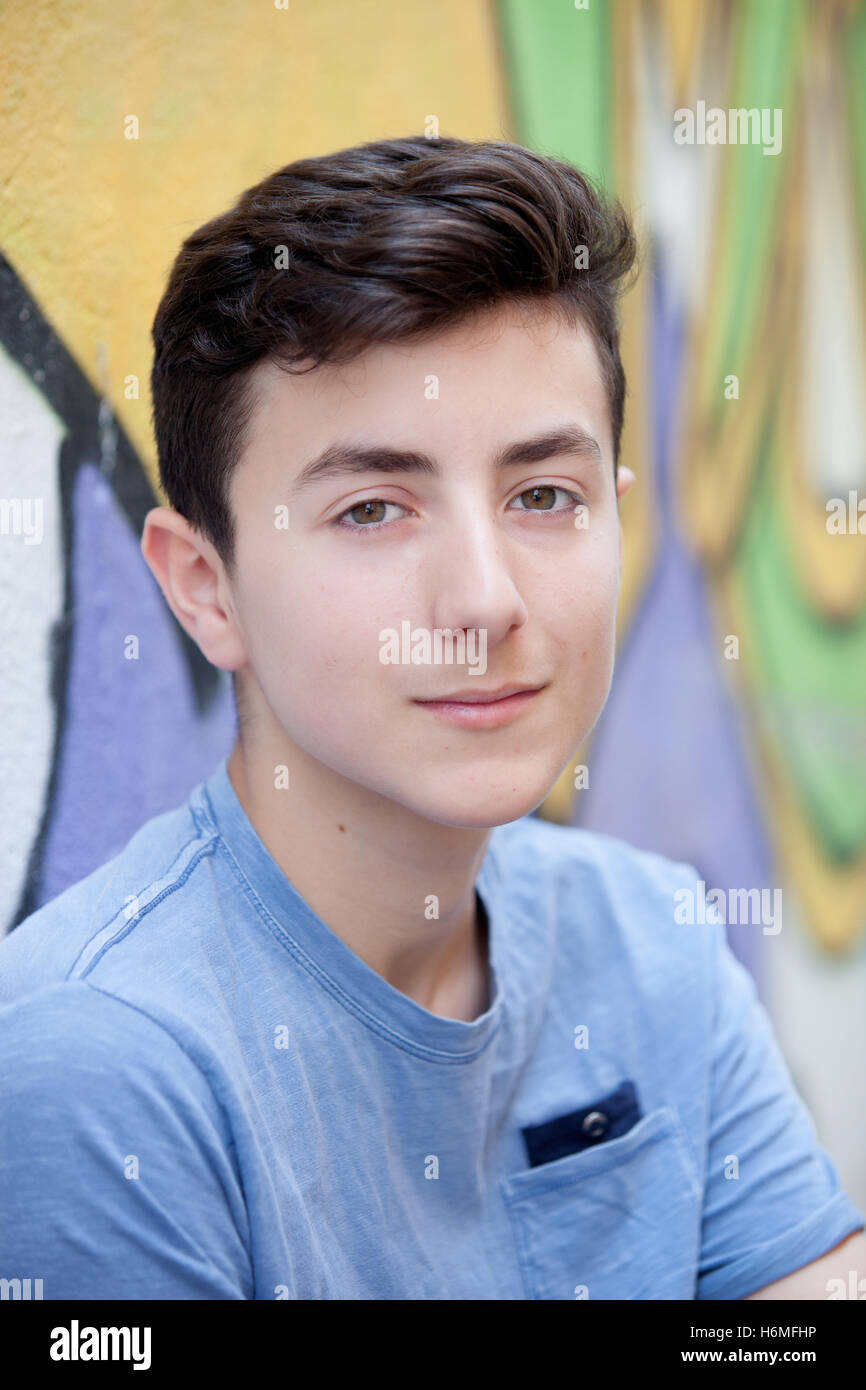 Portrait of a teenager rebellious man on a wall with graffiti ...