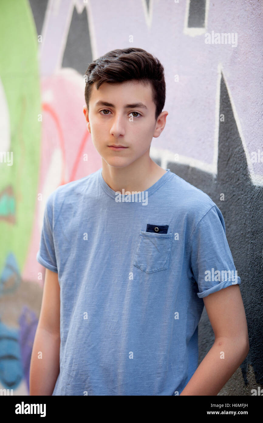 Portrait of a teenager rebellious man on a wall with graffiti ...
