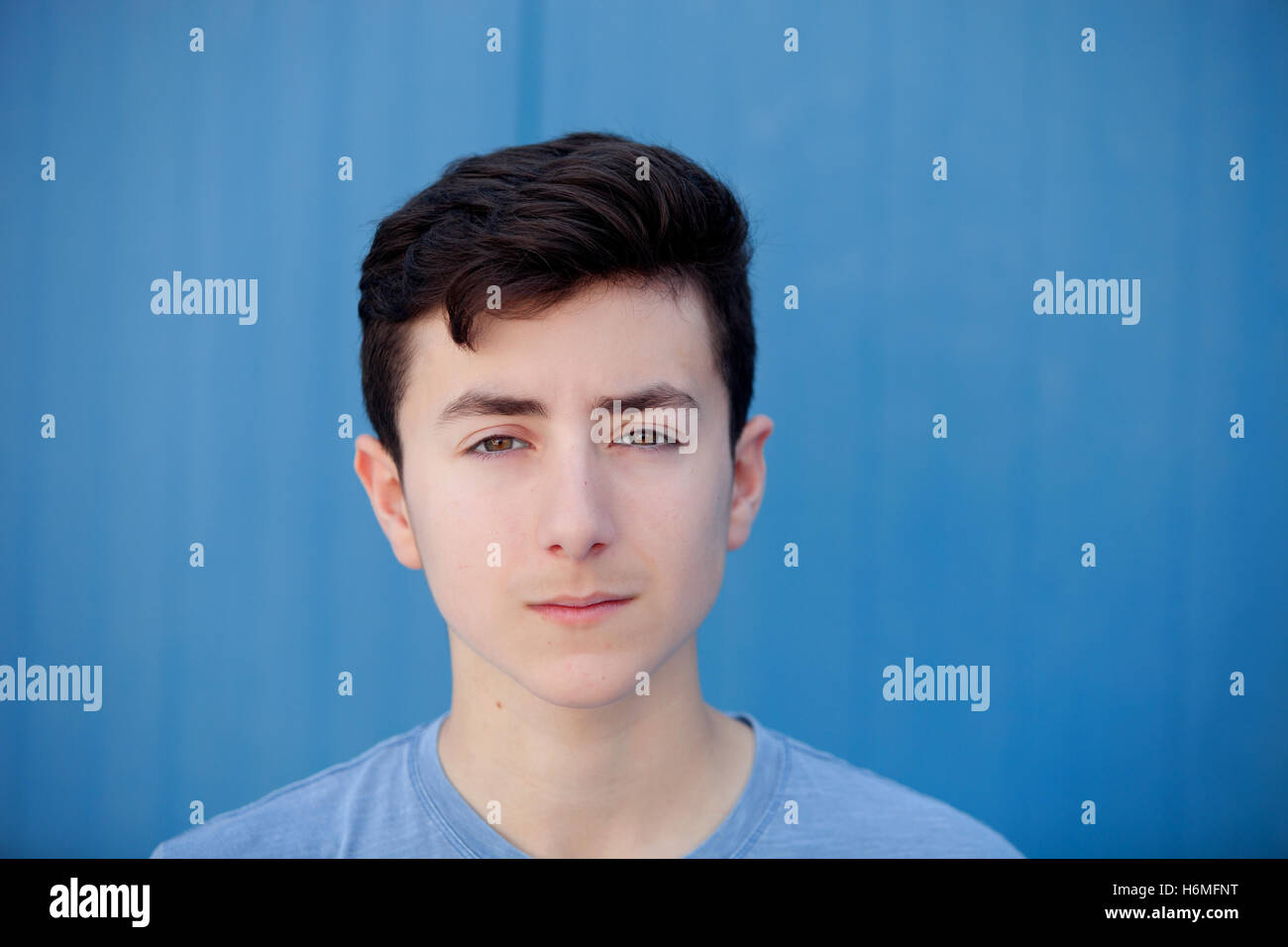 Portrait of a teenager rebellious man with a blue background Stock ...