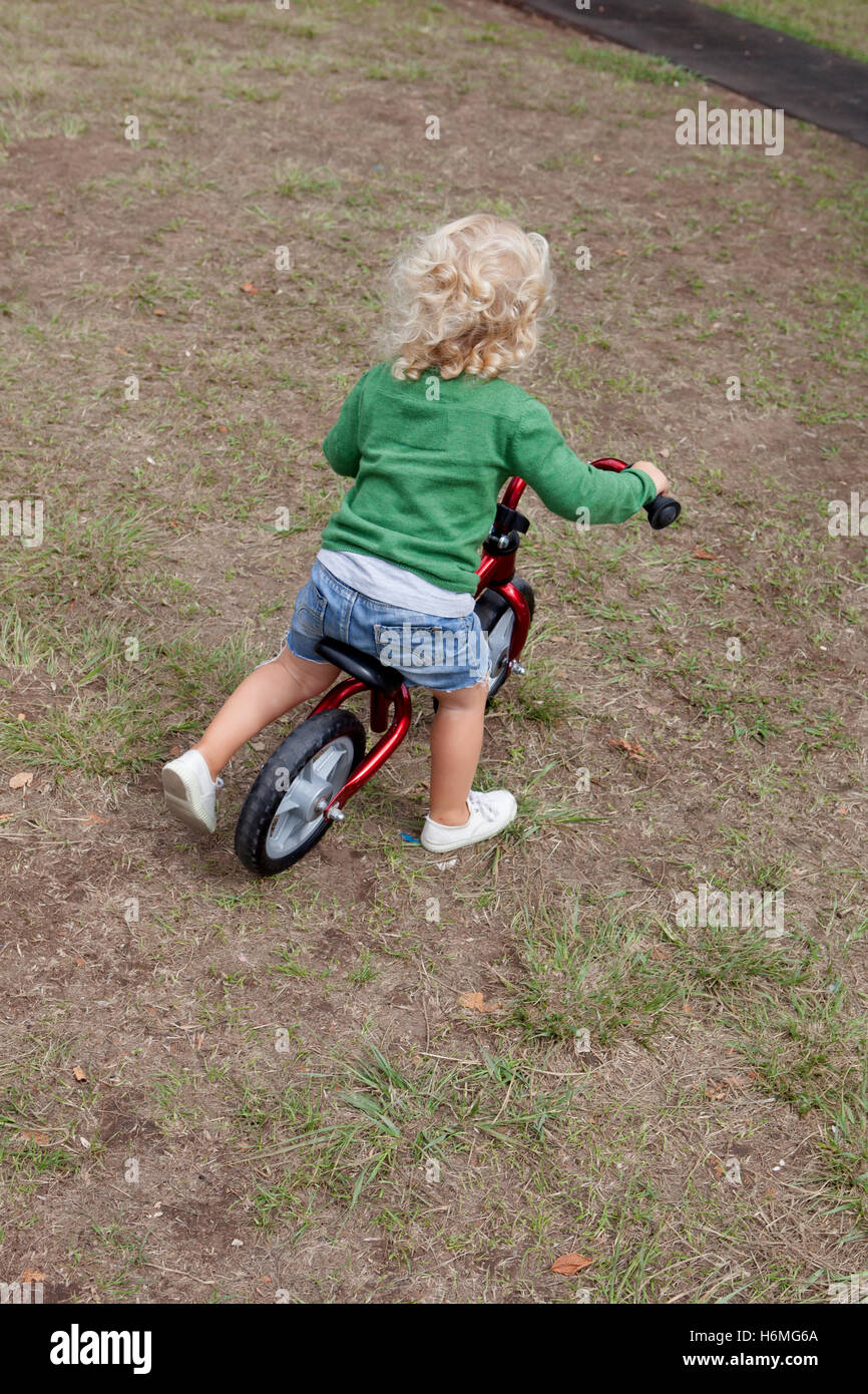 Little kid riding his bike down the street Stock Photo - Alamy