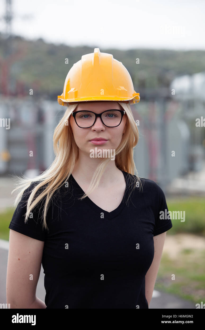 Young engineer with yellow helmet near his workplace Stock Photo - Alamy