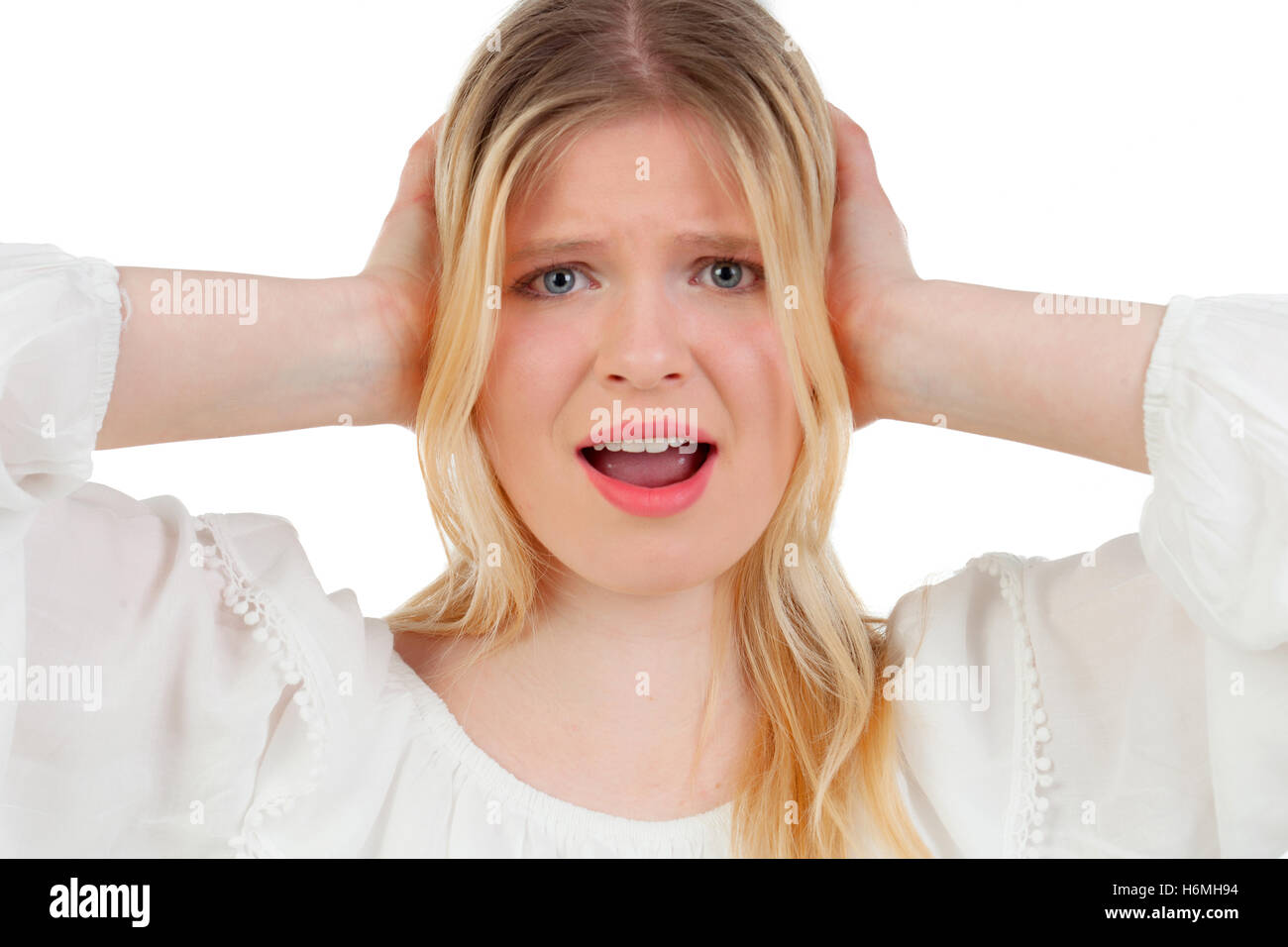 Blonde girl covering her ears isolated on a white background Stock ...