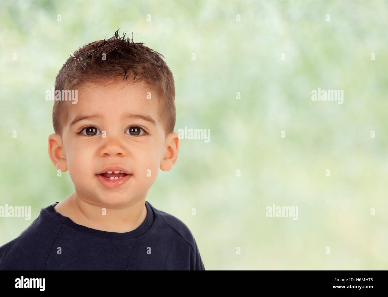 Adorable baby nine months looking at camera with green background Stock ...