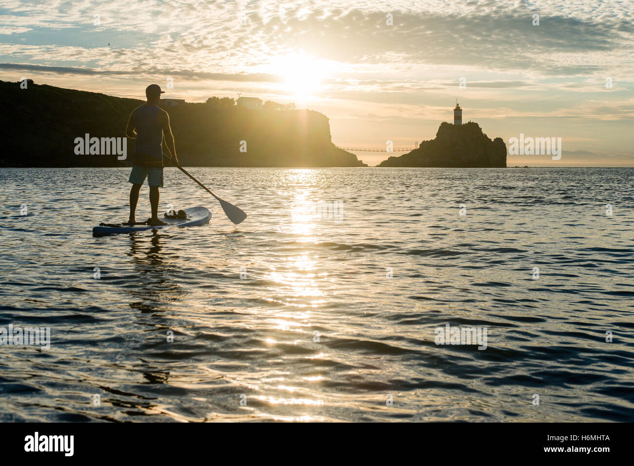 Silhouettes of beautiful couple with sup serf Stock Photo - Alamy