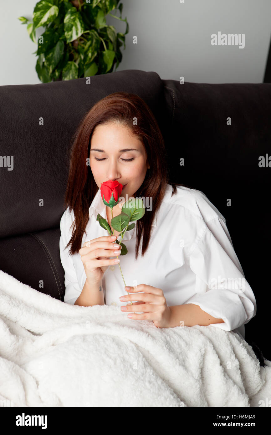 Excited young woman with a red rose on her couch Stock Photo - Alamy