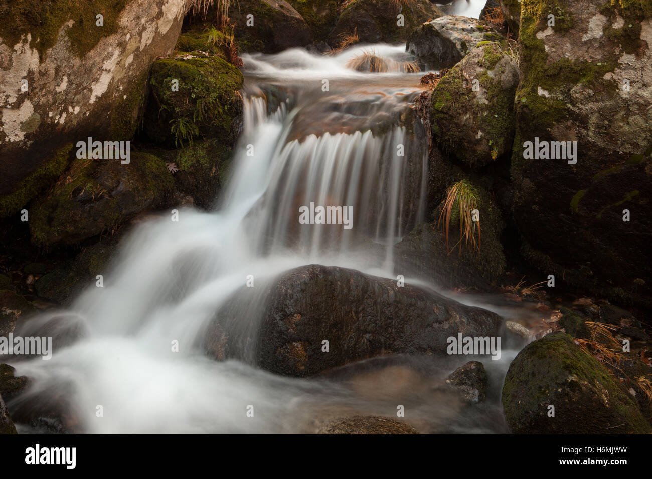 Beautiful waterfall falling on a stones with moss Stock Photo - Alamy