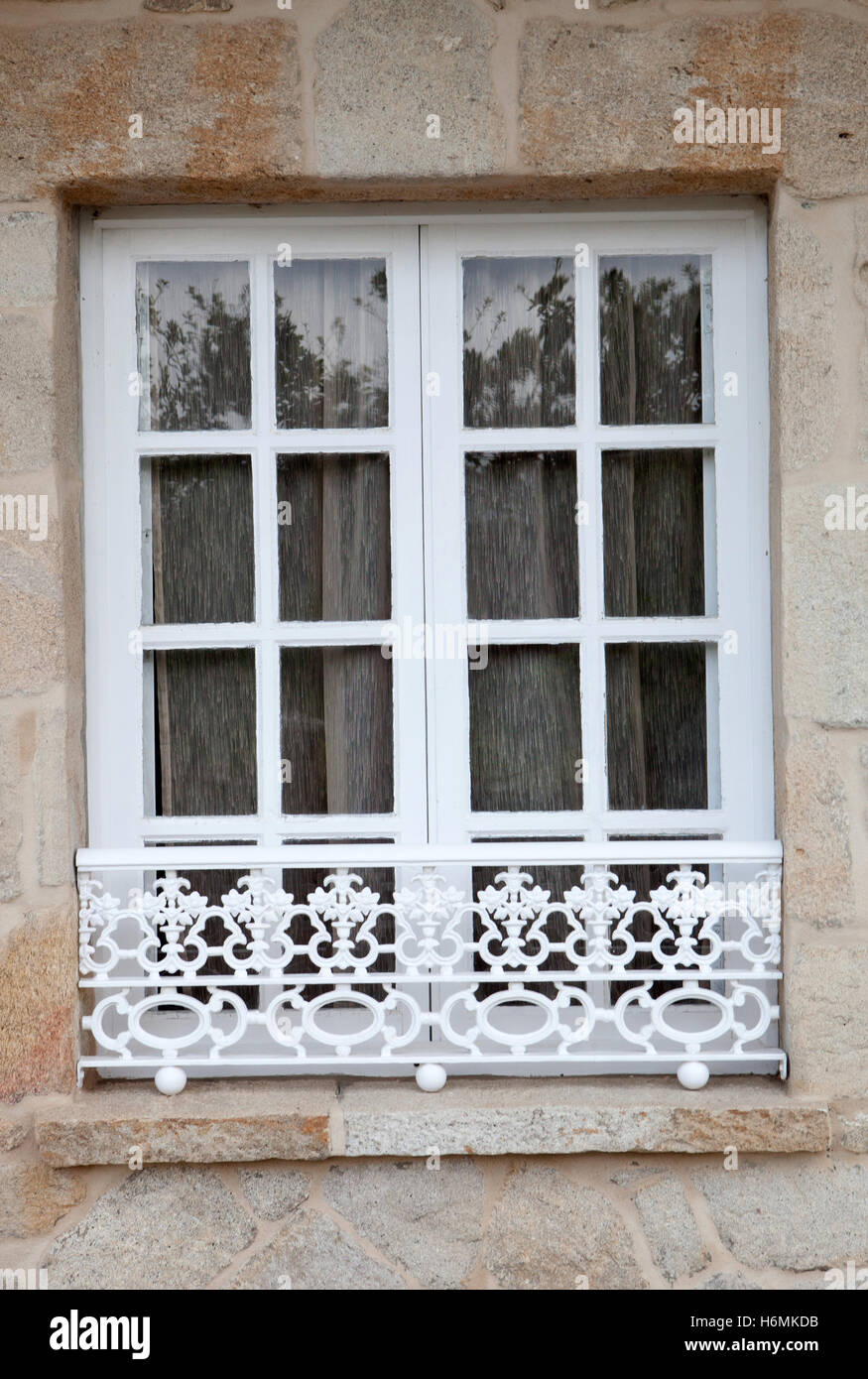 Nice window with white wrought into a stone wall Stock Photo - Alamy
