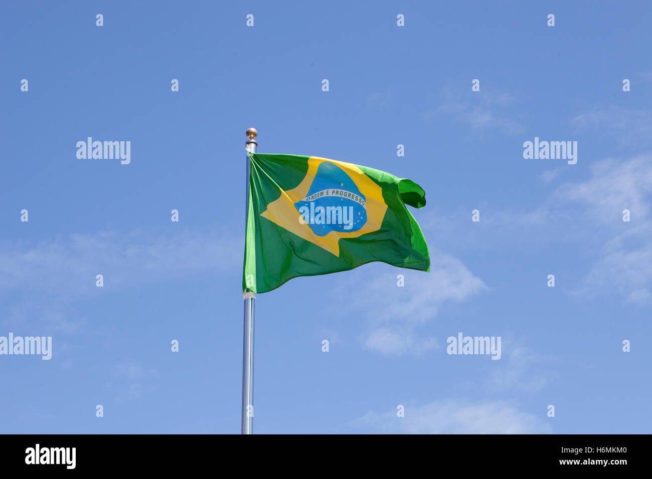 Brazilian flag waving in the mast with blue sky background Stock Photo ...