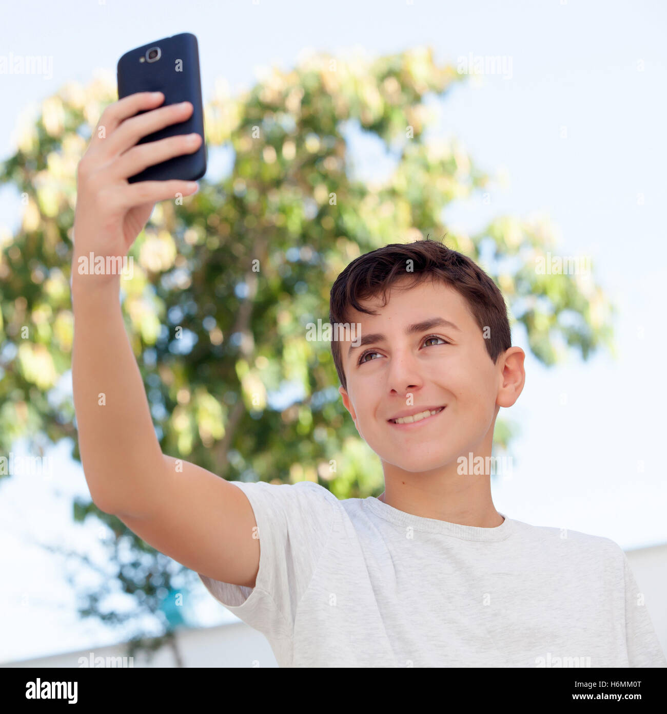 Teen boy getting a photo with the phone in the street Stock Photo - Alamy