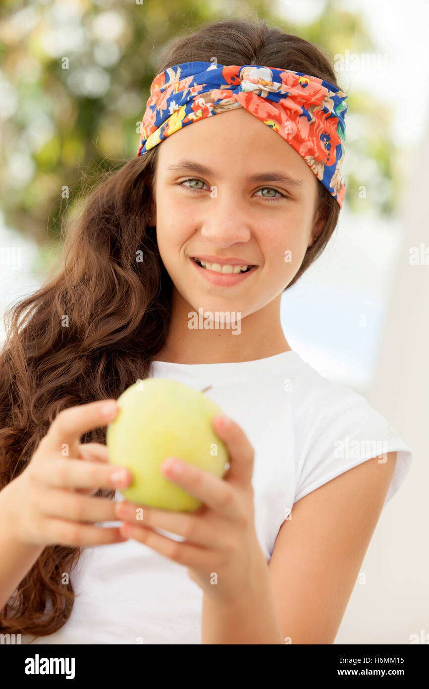 Teenager girl with blue eyes eating a apple Stock Photo - Alamy