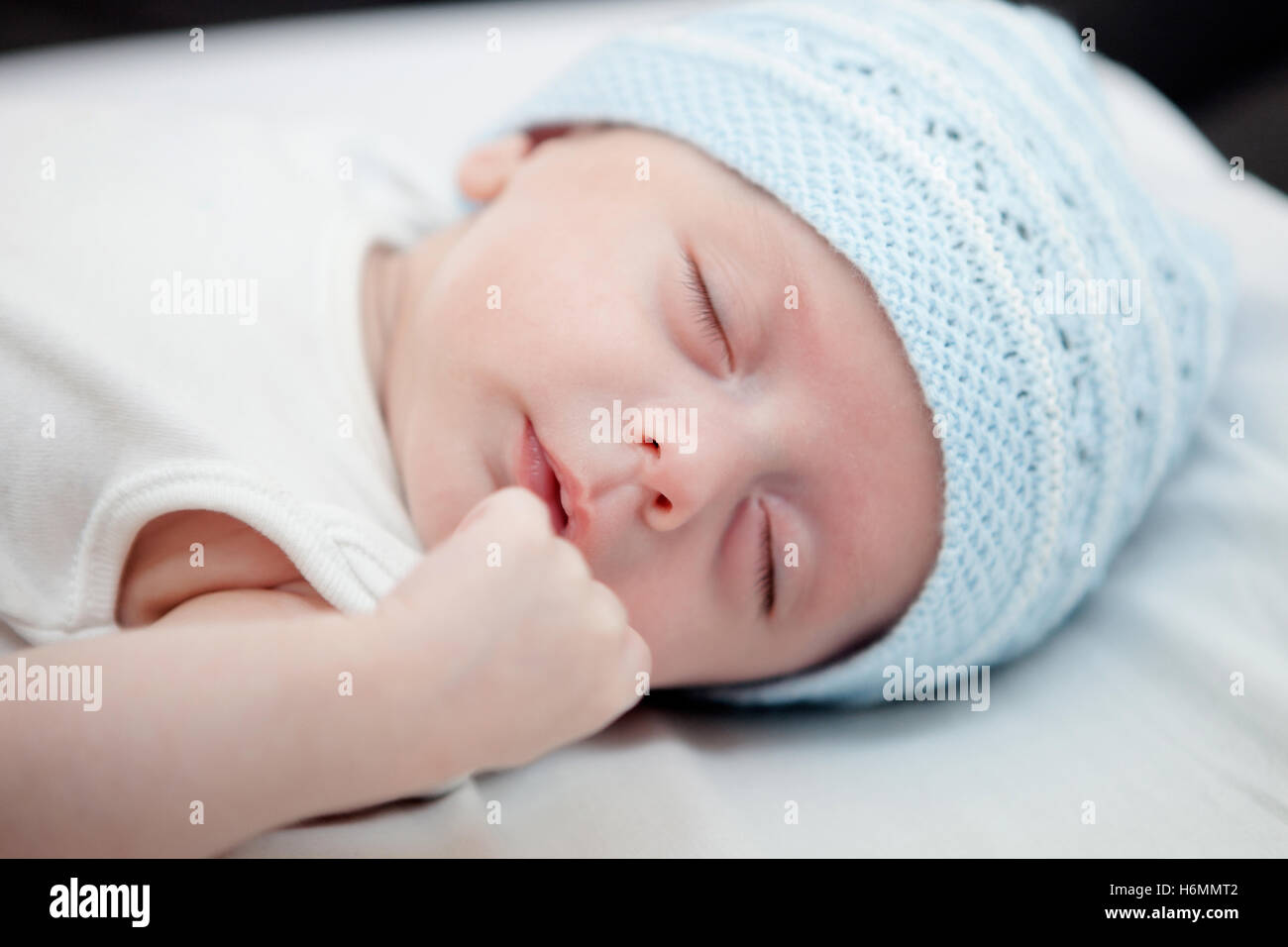 Beautiful baby with blue cap sleeping peacefully Stock Photo - Alamy