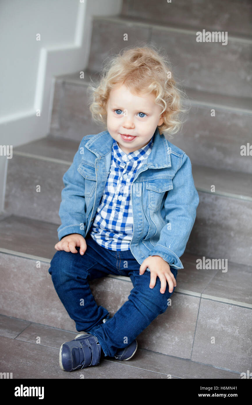 Small boy sitting on stairs hi-res stock photography and images - Alamy