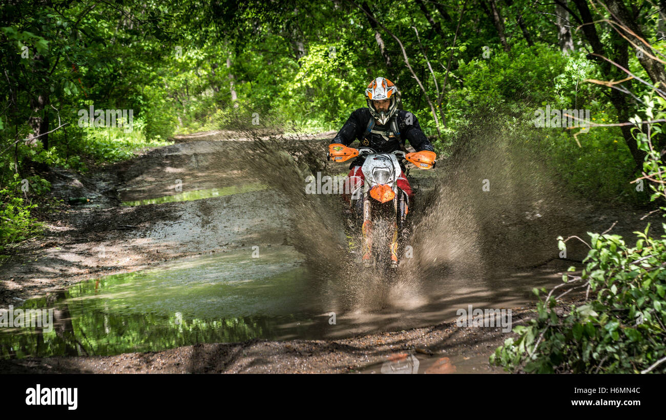 enduro moto in the mud with a big splash Stock Photo - Alamy