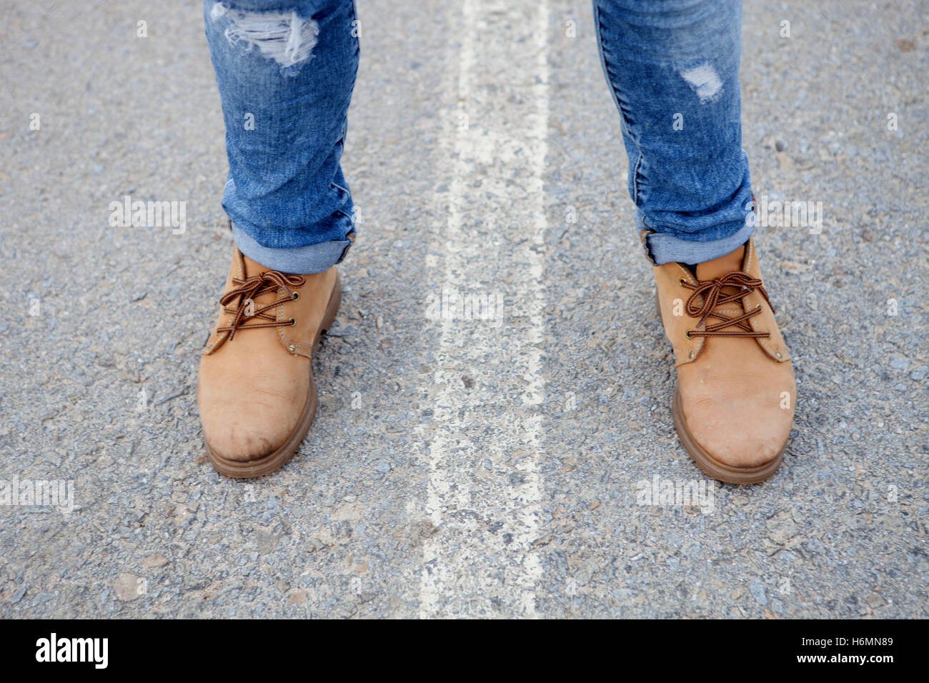 Old boots treading on the road. Starting way Stock Photo - Alamy