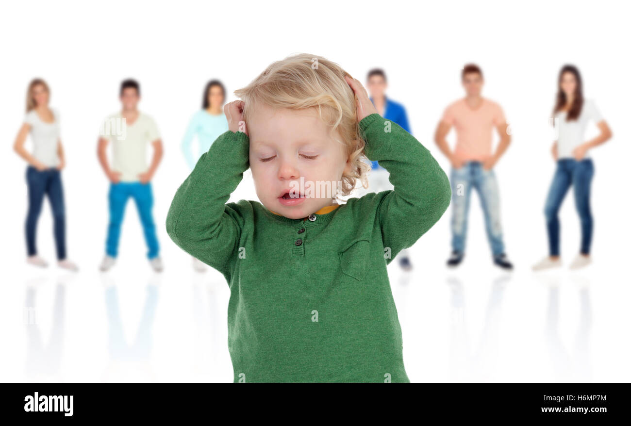Worried blonde baby with people unfocused background Stock Photo - Alamy