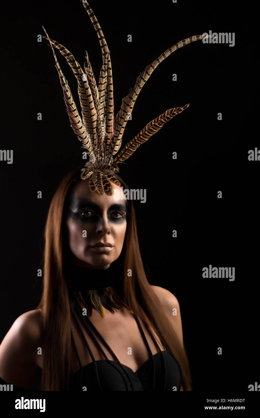 Tanned female model in amazonian superhero outfit with feather ...