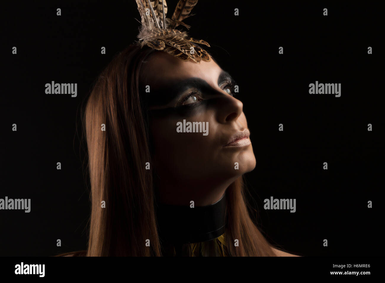 Tanned female model in amazonian superhero outfit with feather ...