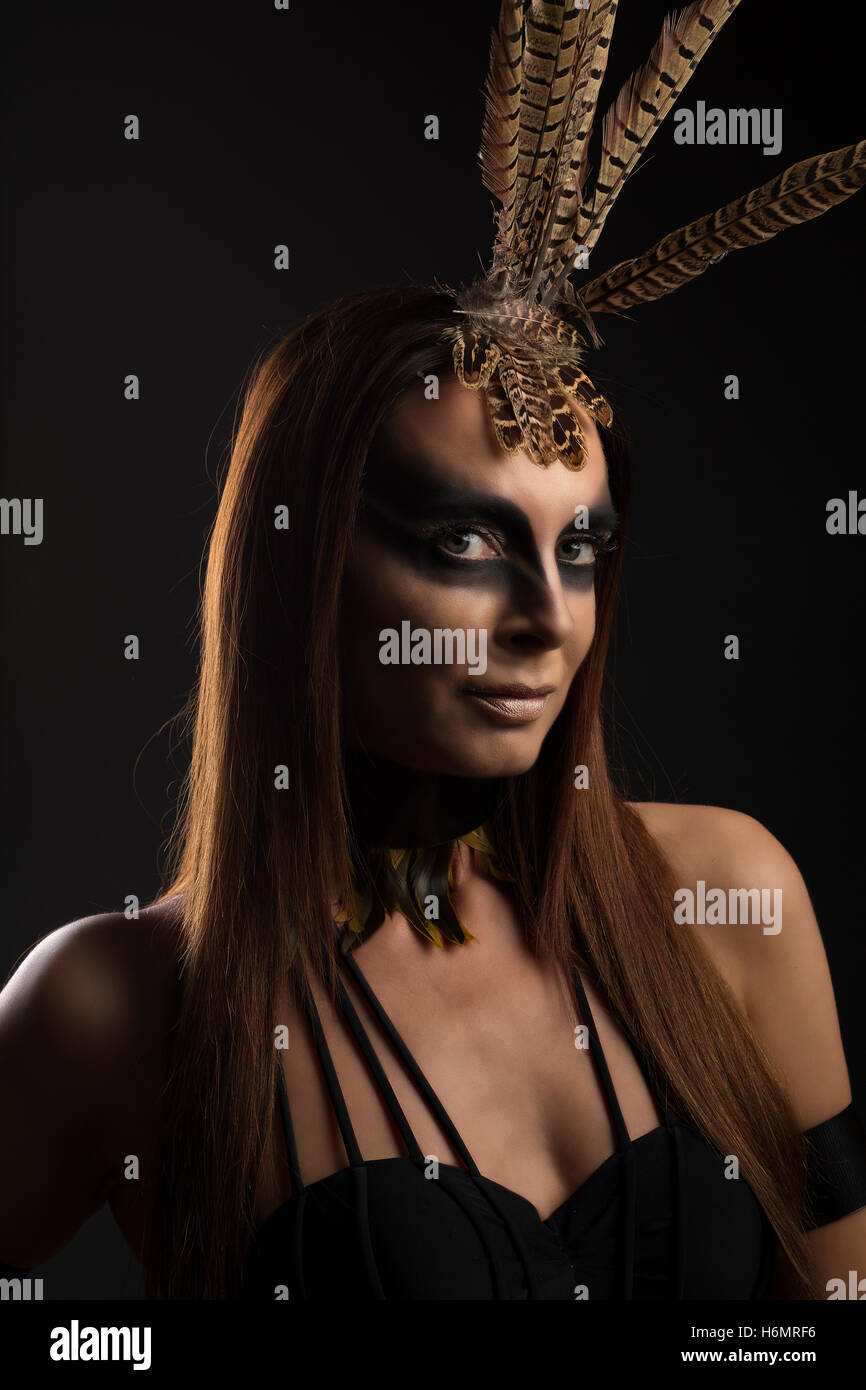 Tanned female model in amazonian superhero style outfit with feather ...