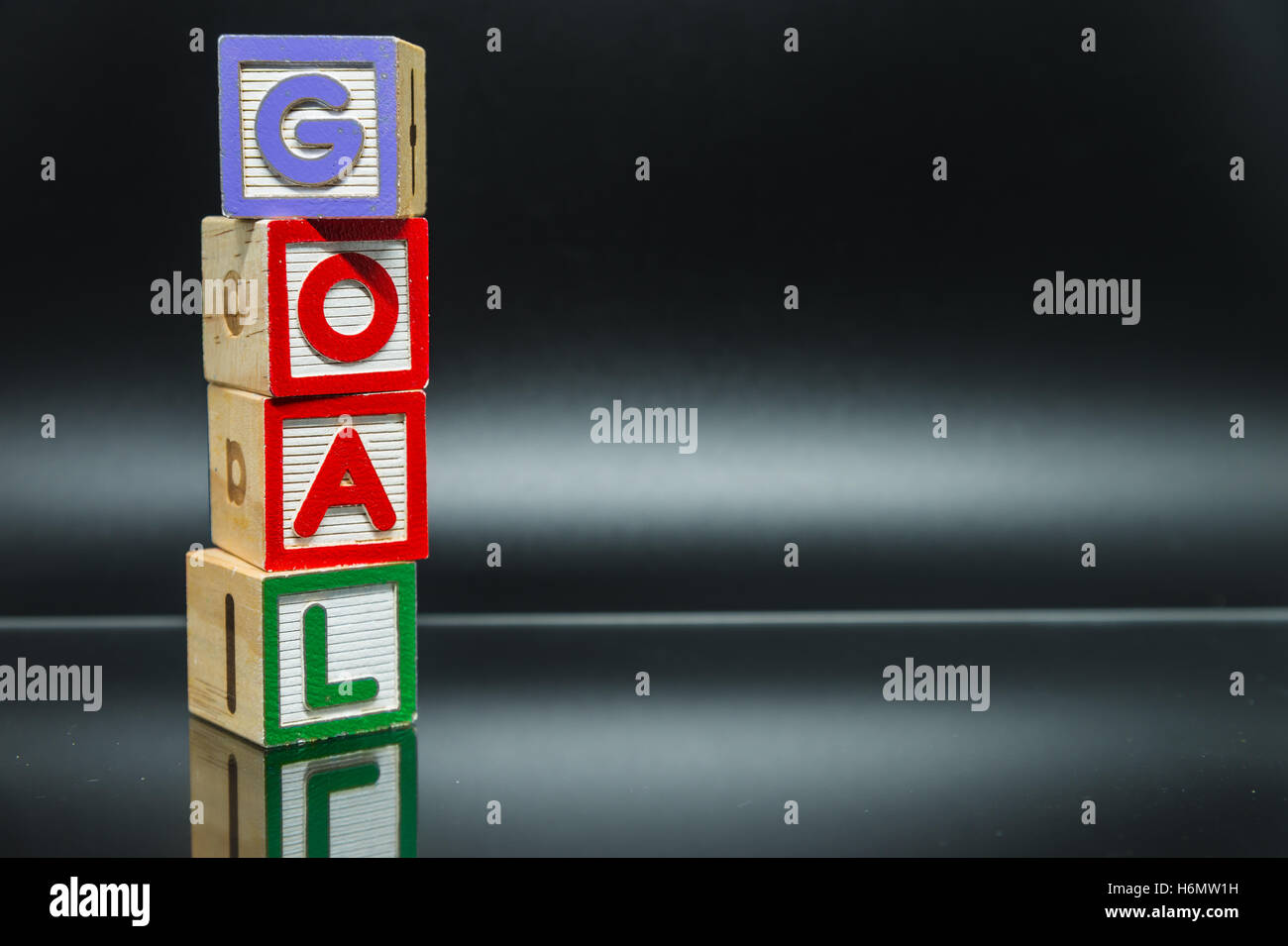 GOAL word wooden block arrange in vertical style on black background ...
