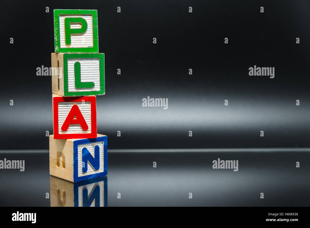 PLAN word wooden block arrange in vertical style on black background ...
