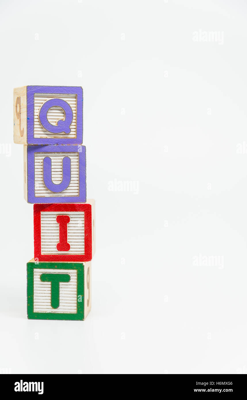 QUIT word wooden block arrange in vertical style on white background ...