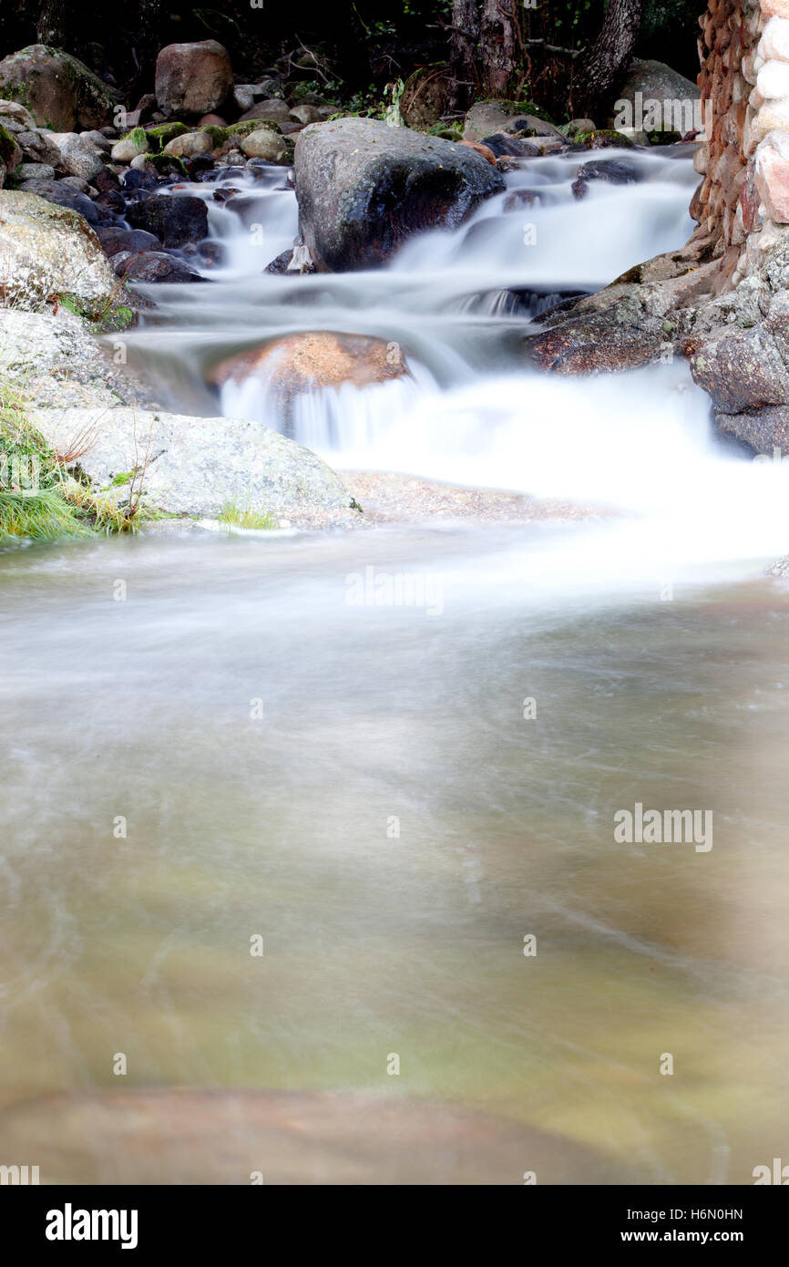Nice creek with clear water flowing between the rocks Stock Photo - Alamy